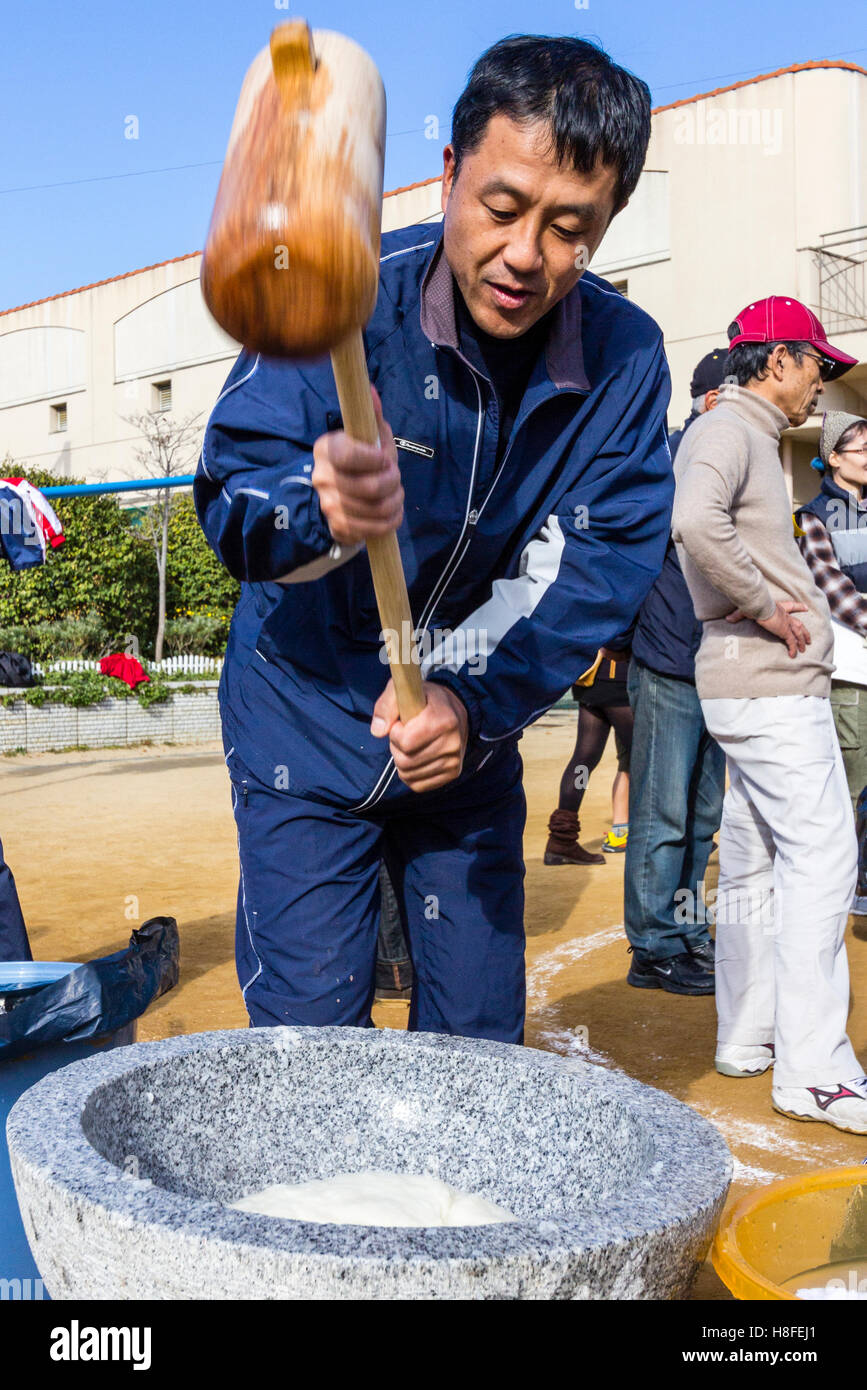 Japan. Omochi, winter rice bashing festival. Man holding with both ...