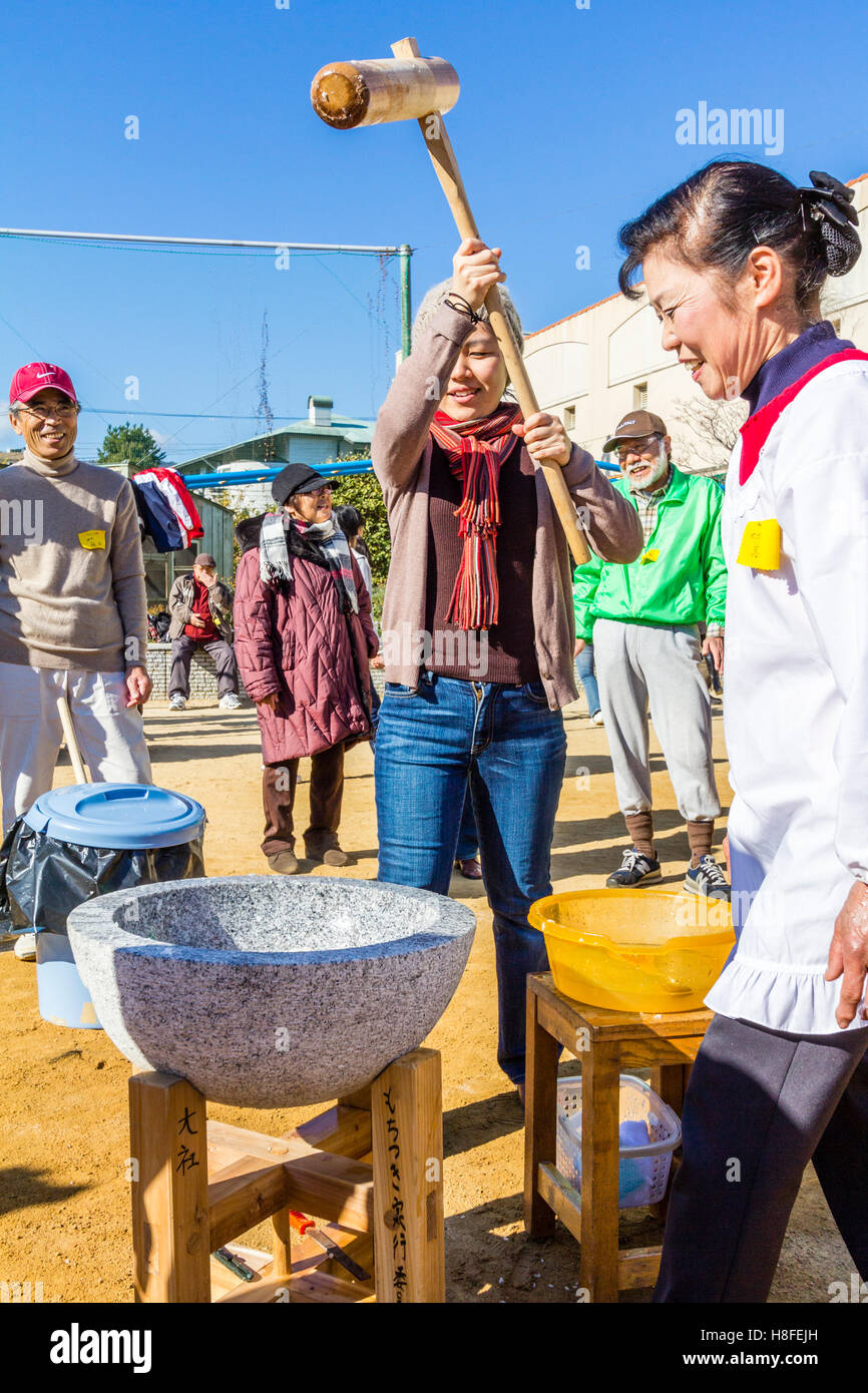 Japan. Omochi, winter rice bashing festival. Woman holding with both ...