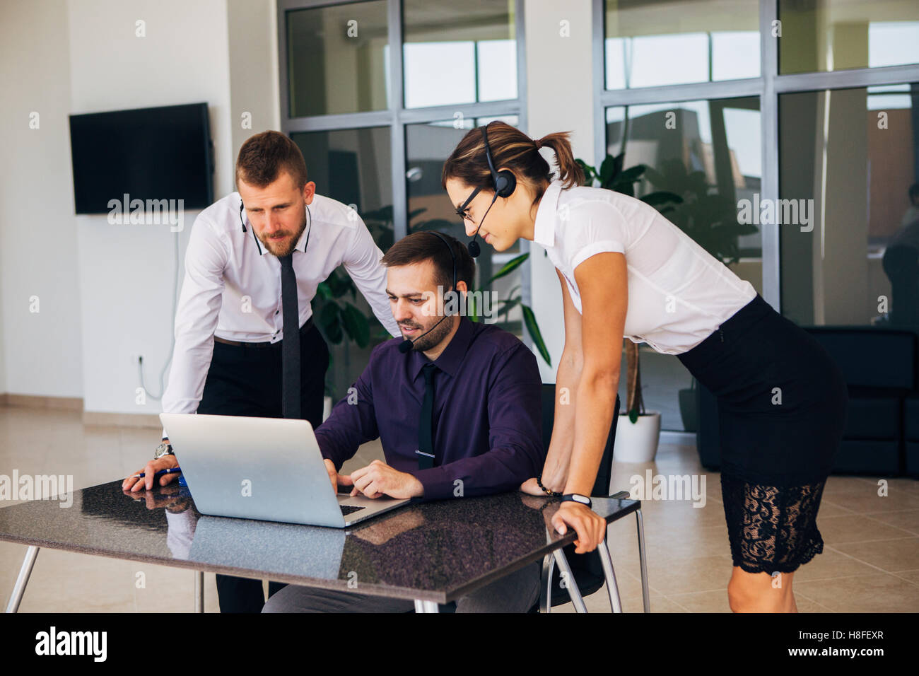 Sales assistants working with computers in an office Stock Photo - Alamy