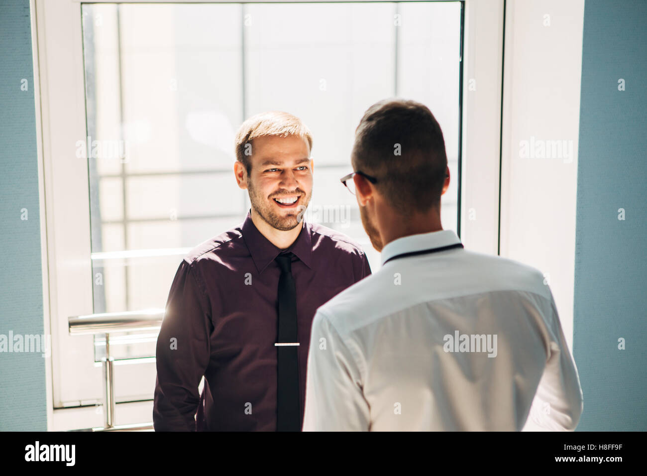 two men talking in the lobby of the office Stock Photo - Alamy