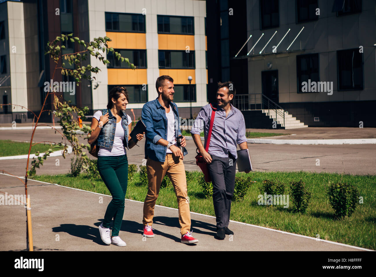 three students walking on campus Stock Photo - Alamy