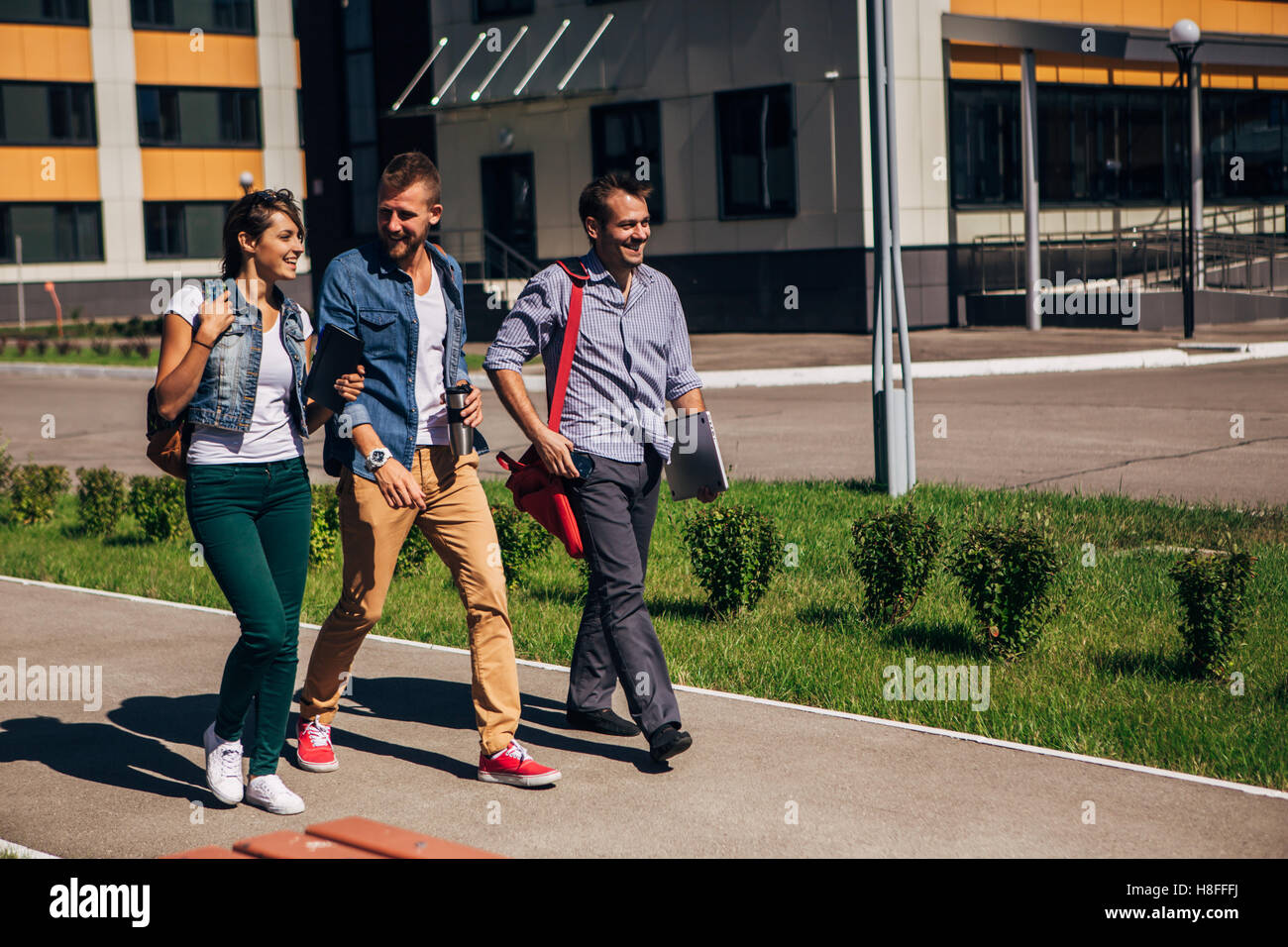 three students walking on campus Stock Photo - Alamy