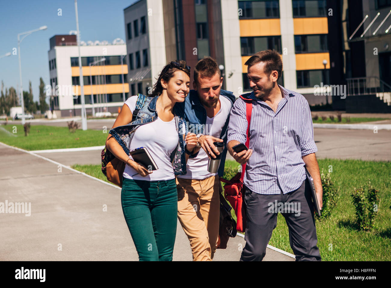 Young students walking outside campus building Stock Photo - Alamy