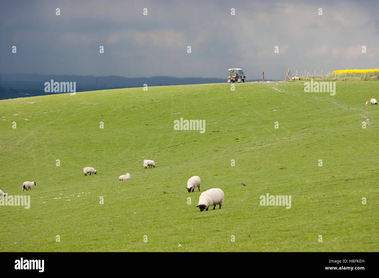 BUCKINGHAMSHIRE, UK A farmer's Land Rover crests a hill as a storm ...