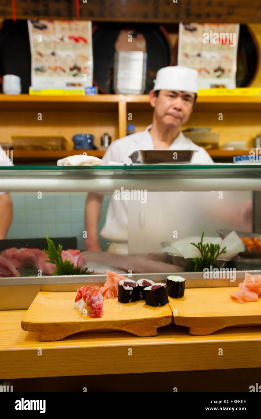 TOKYO, JAPAN Sushi chef behind the counter in a sushi restaurant in the ...