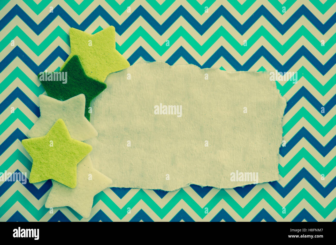 green christmas stars and blank board over blue pattern background ...