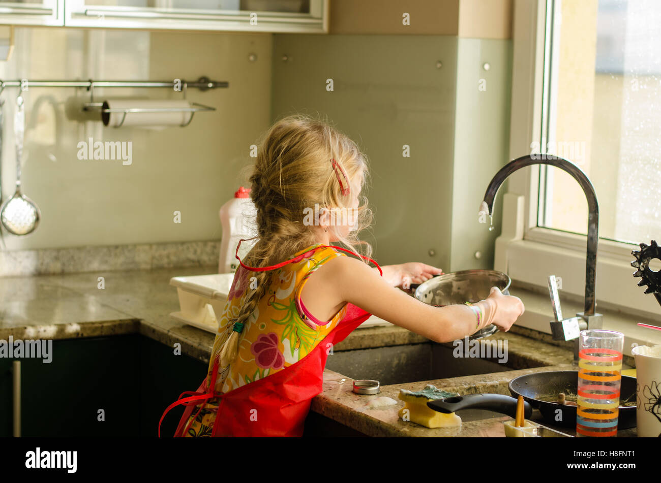 little lovely girl washing dishes in the kitchen Stock Photo - Alamy