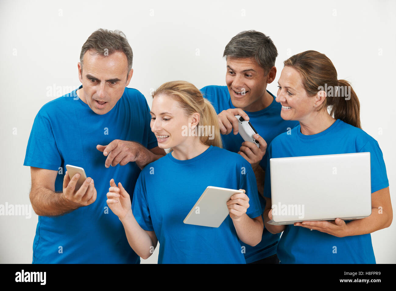 Sales Team Wearing Uniform With Selection Of Techno Gadgets Stock Photo ...