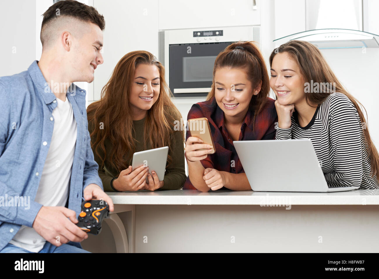 Group Of Teenagers Using Digital Technology At Home Stock Photo - Alamy