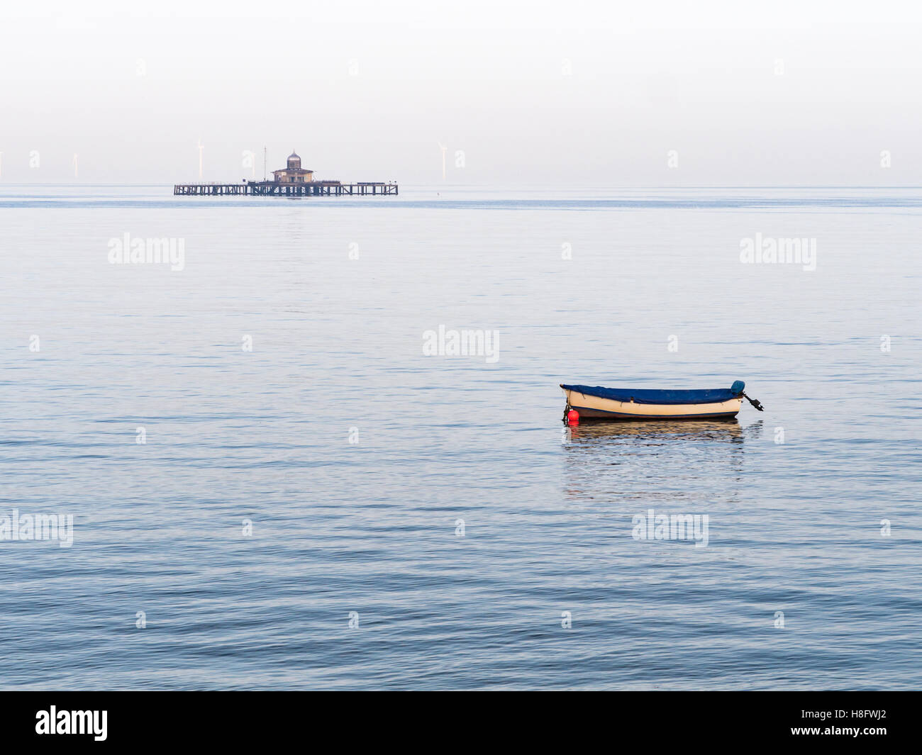 A small covered wooden boat covered and anchoured in Herne Bay, Kent ...