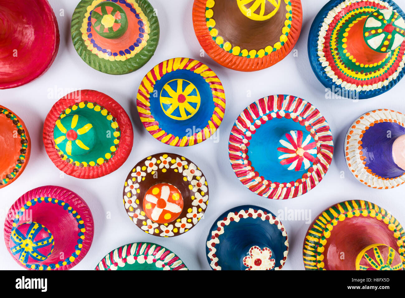 Top view of colorful painted handmade pottery lids on white background ...