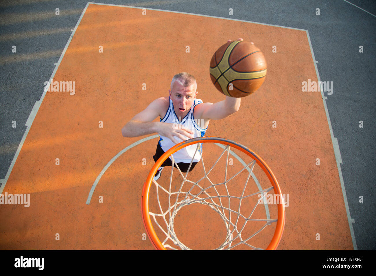 Basketball street player making a slam dunk Stock Photo - Alamy