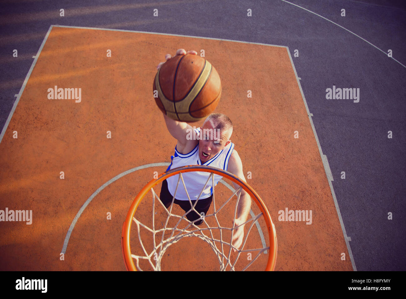 Basketball street player making a slam dunk Stock Photo - Alamy