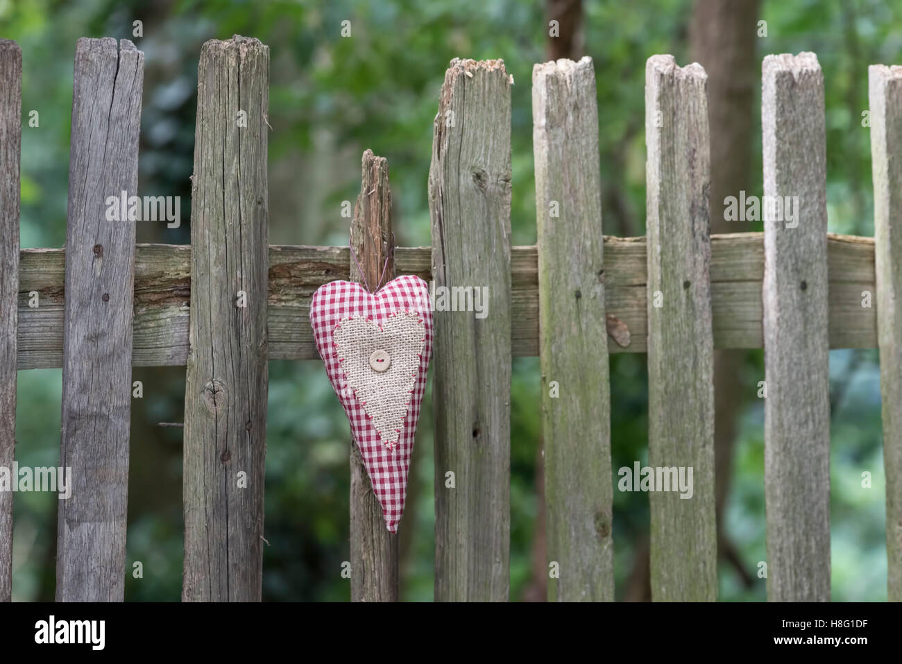 Rustic fabric heart, red checked, on old stockade Stock Photo - Alamy