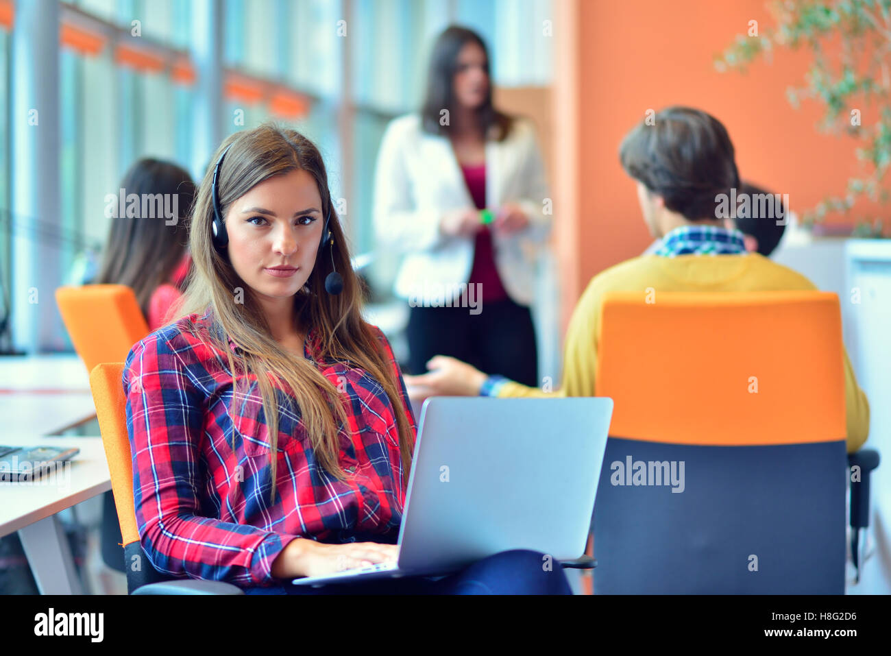 Cute businesswoman in an office with colleagues at the background Stock ...