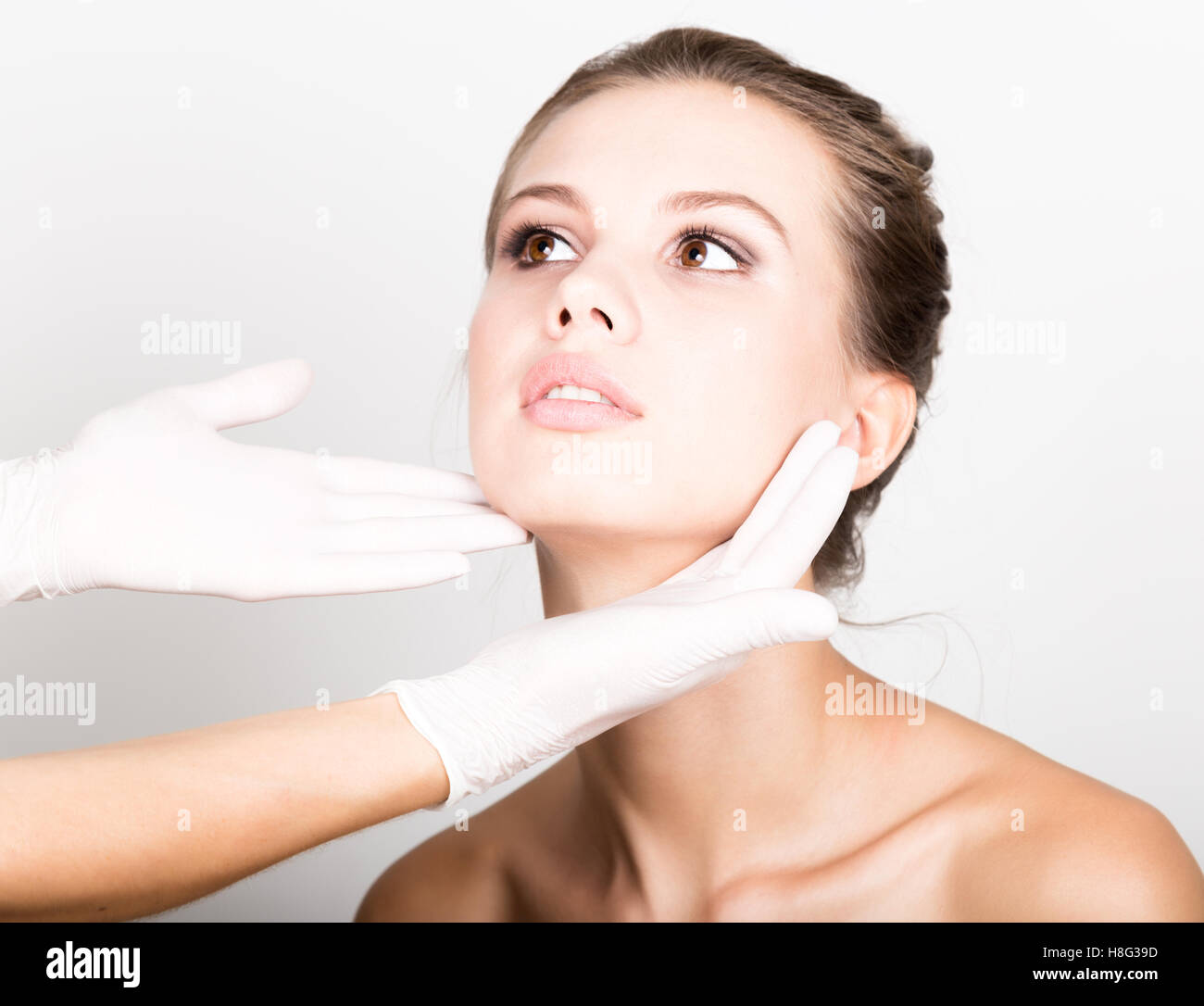 beautician hand's examining beautiful young female face Stock Photo - Alamy
