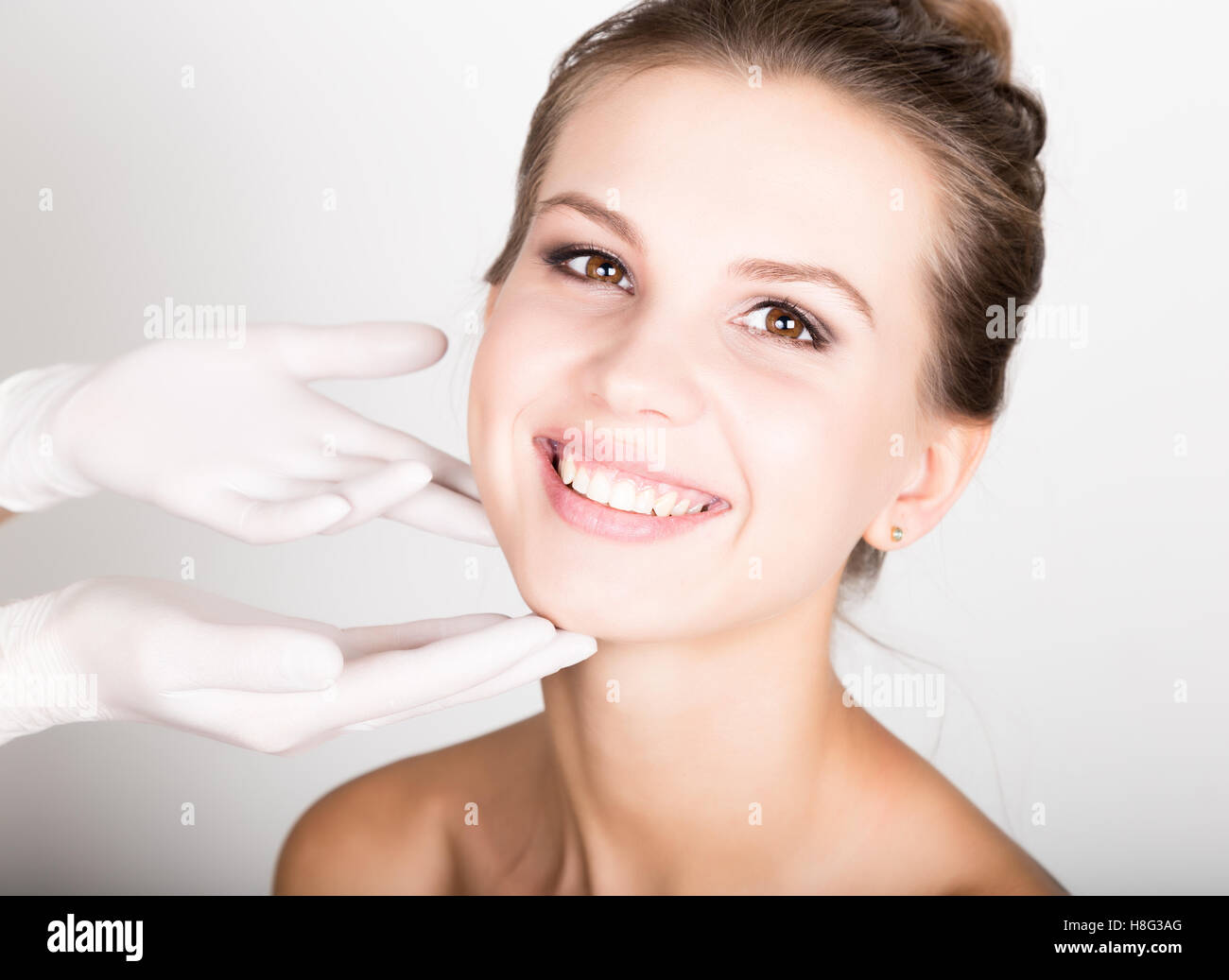 beautician hand's examining beautiful young female face Stock Photo - Alamy