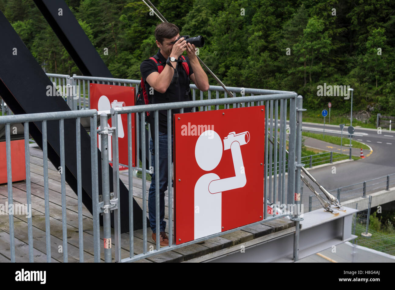Young caucasian male taking a picture with his camera from a viewpoint ...