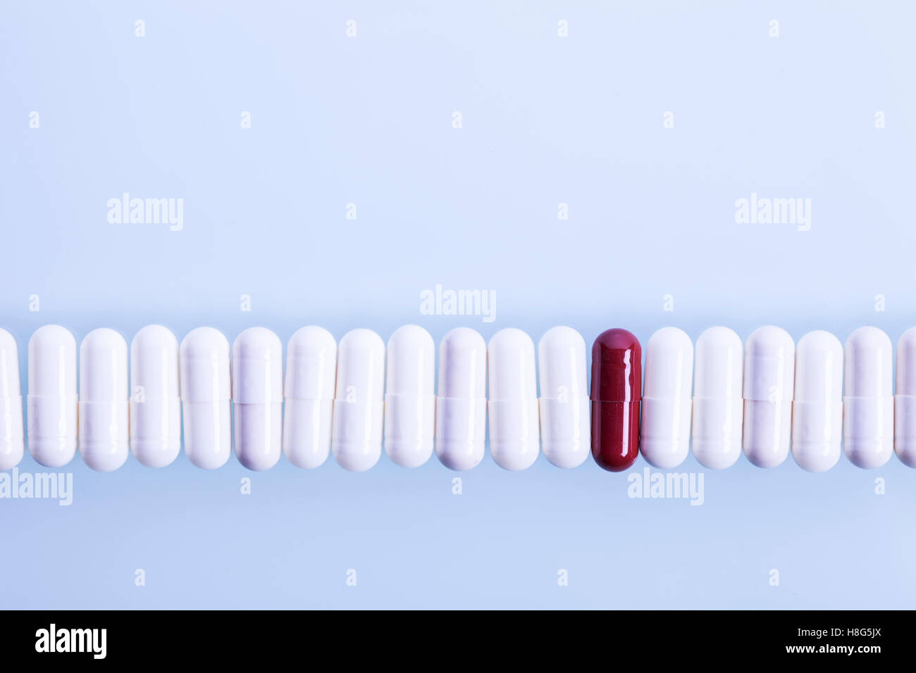 White capsules and one red in line. Studio shot Stock Photo - Alamy