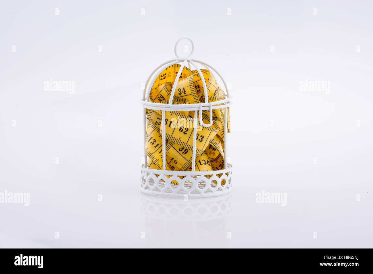 Yellow color measuring tape in a cage on a white background Stock Photo ...