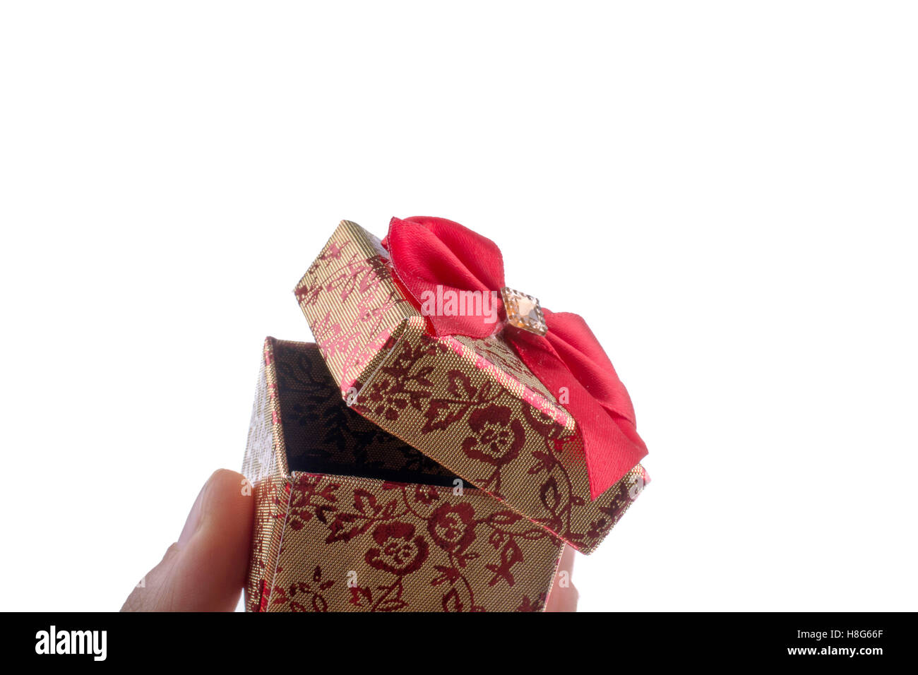 Hand holding a gift box with a red ribbon Stock Photo - Alamy