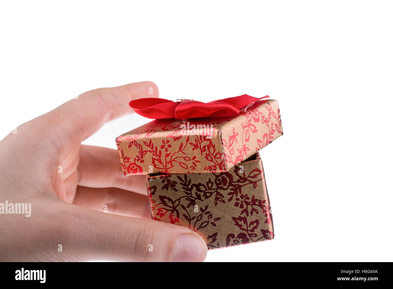 Hand holding a gift box with a red ribbon Stock Photo - Alamy