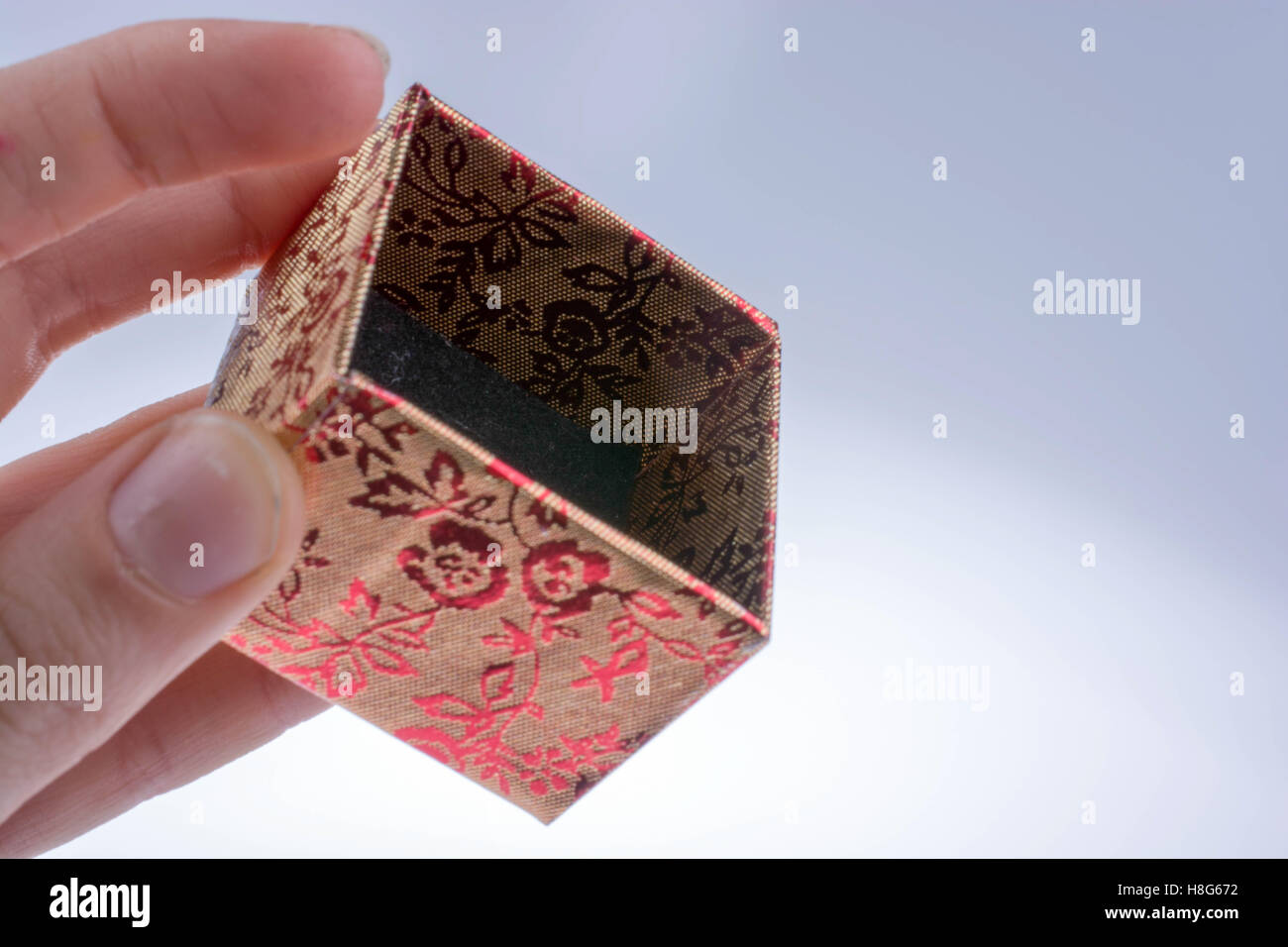 Hand holding a gift box with a red ribbon Stock Photo - Alamy