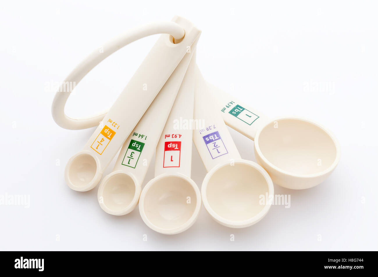 measuring spoons in varying sizes on white background kitchen object ...