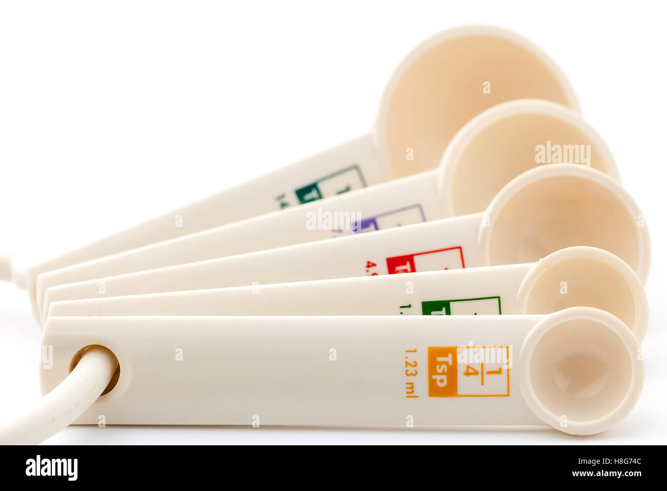 measuring spoons in varying sizes on white background kitchen object ...