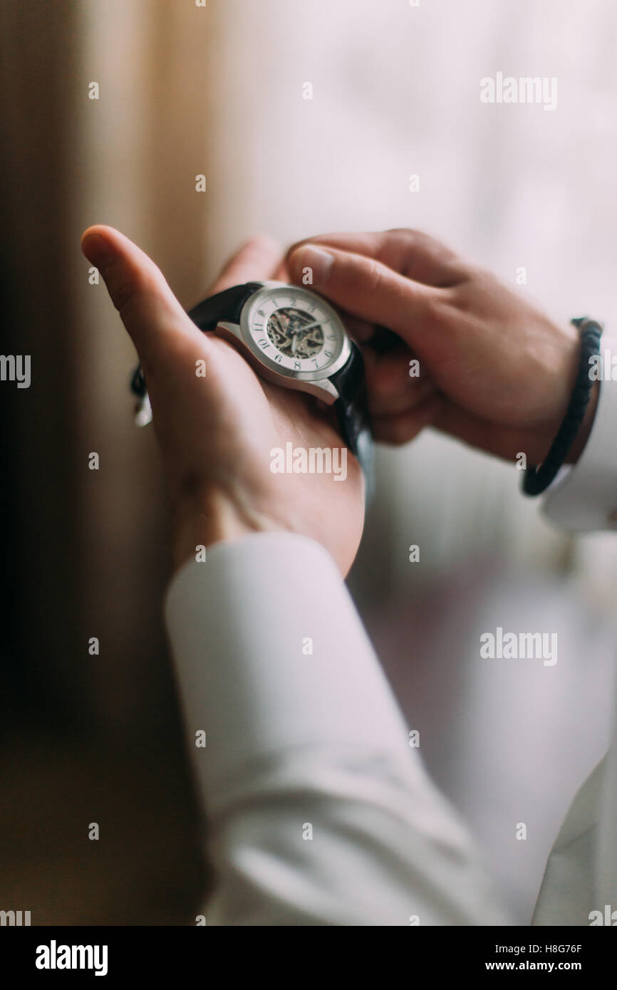 Men's hands holding and winding up mechanical watch Stock Photo - Alamy