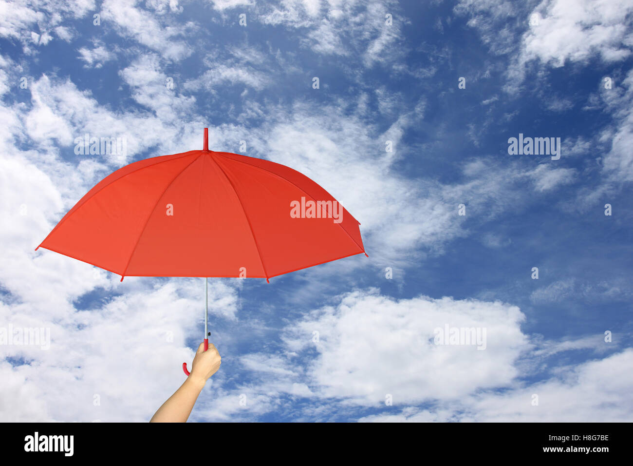 Red umbrella in hand on blue sky and cloud background concept of sun ...