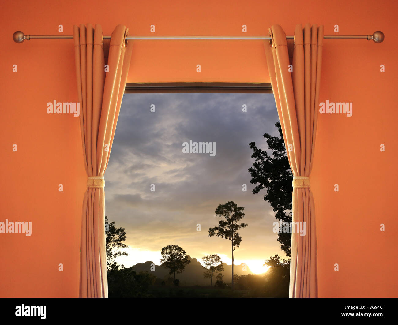 orange room have a window with blinds you can see sunset in evening for ...