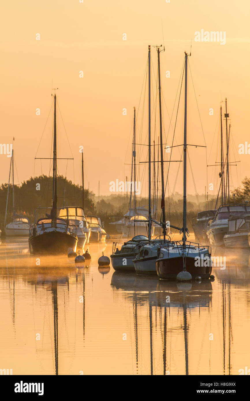boats on misty morning reflecting in water Stock Photo - Alamy