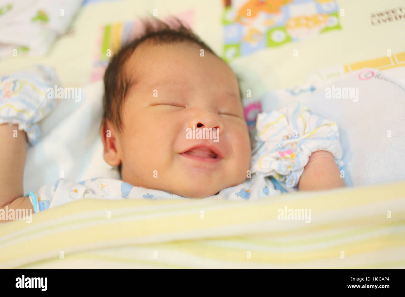 Asian baby smiling happily on bed,concept of health and growth Stock ...