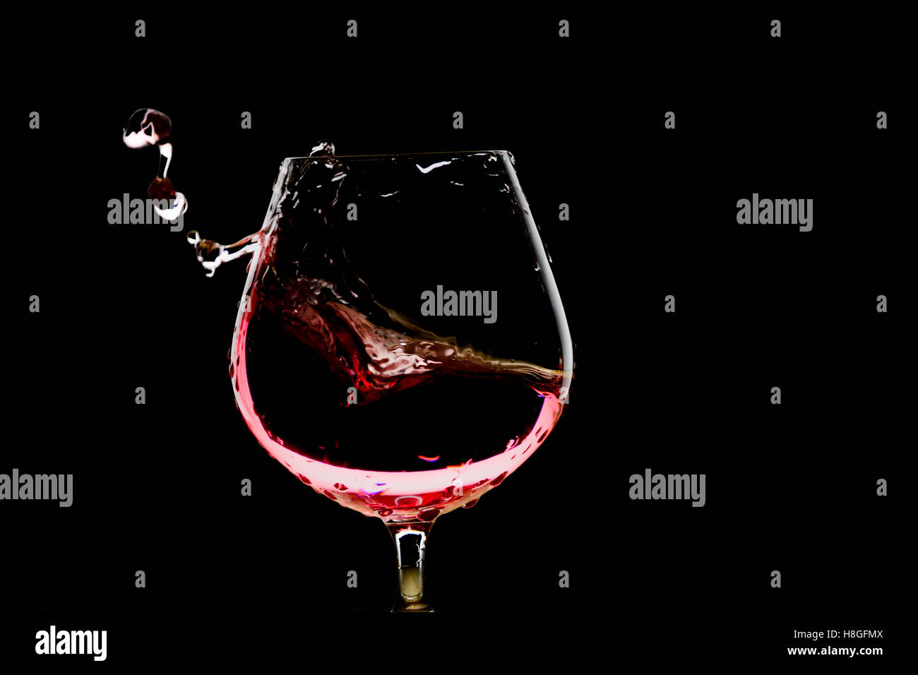 Splash of wine in the glass on dark background Stock Photo - Alamy