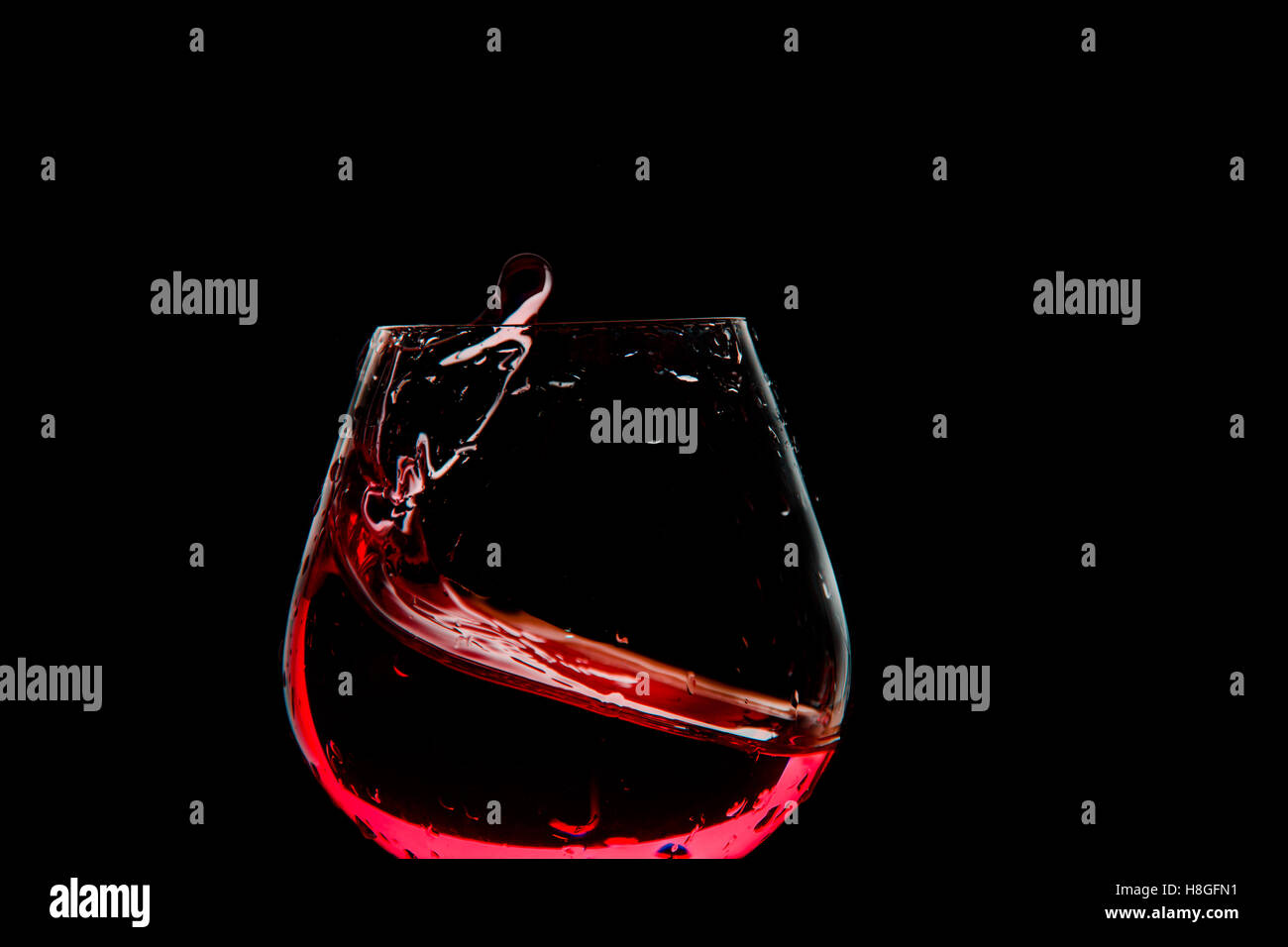 Splash of wine in the glass on dark background Stock Photo - Alamy