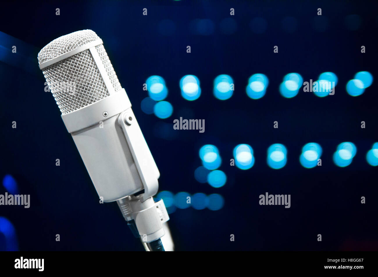 Close up of microphone with lights in background Stock Photo - Alamy