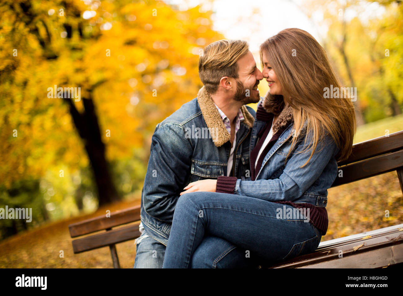 Loving and romantic couple on a bench in the autumn park Stock Photo ...