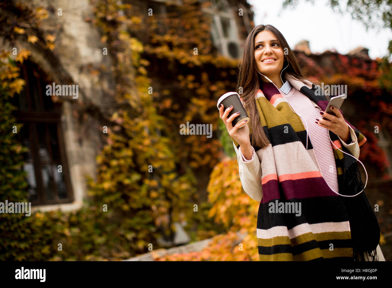 Young woman with mobile phone in autumn Stock Photo - Alamy