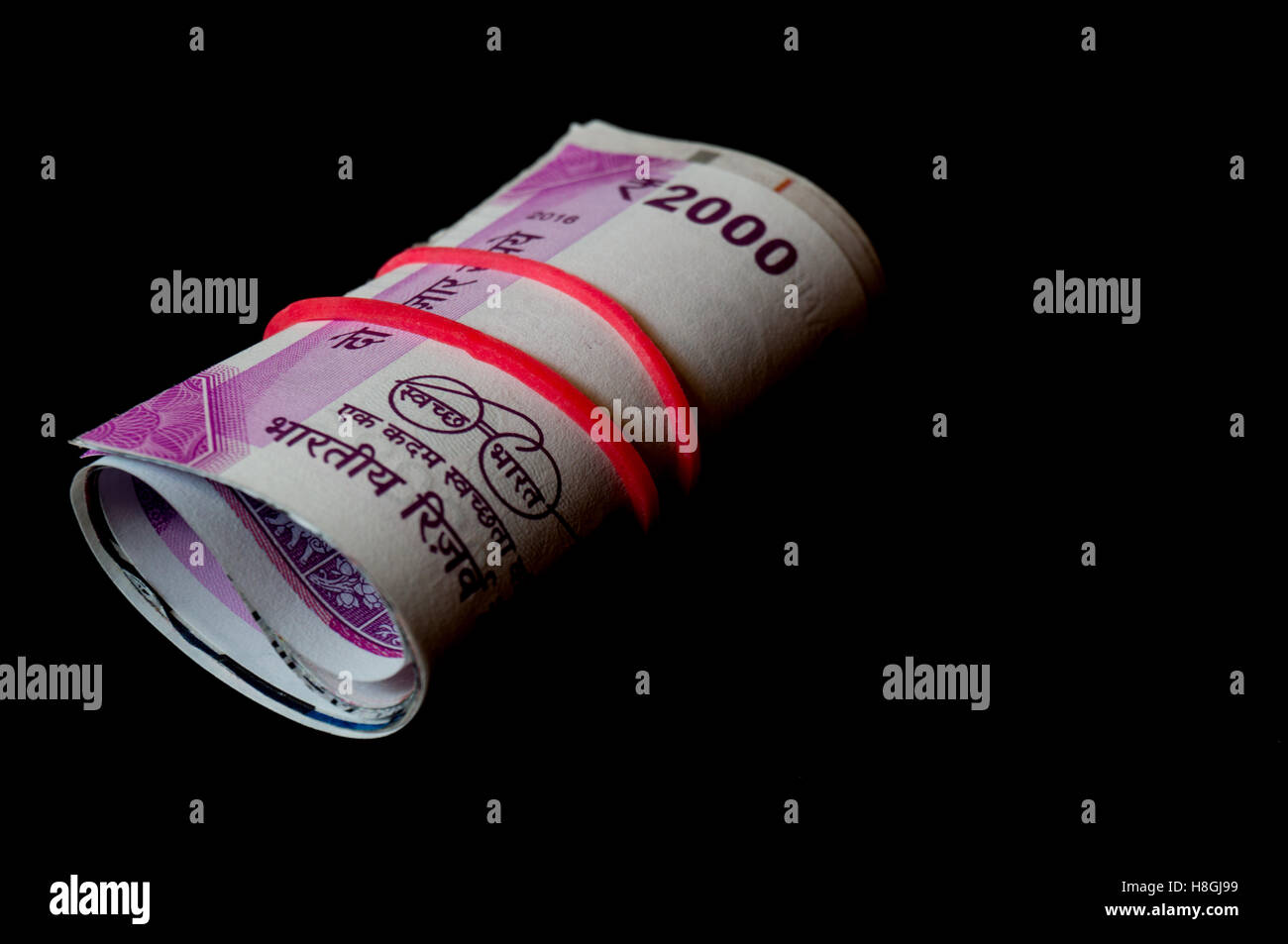 Rolls of the new indian currency. These Rs. 2000 notes are isolated on ...