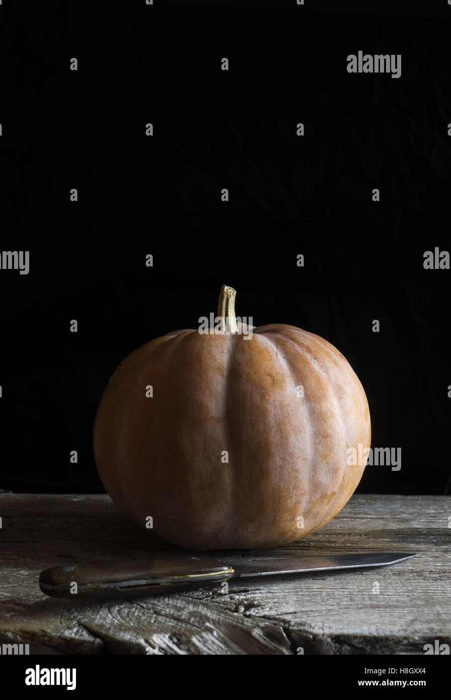 November 13, 2016 - Pumpkin on old weathered table on black background ...