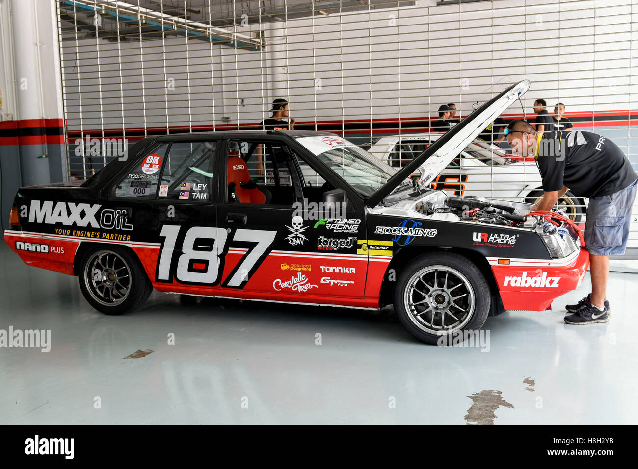 Team Tengku Djan Ley car crew members check the Proton Saga on the ...