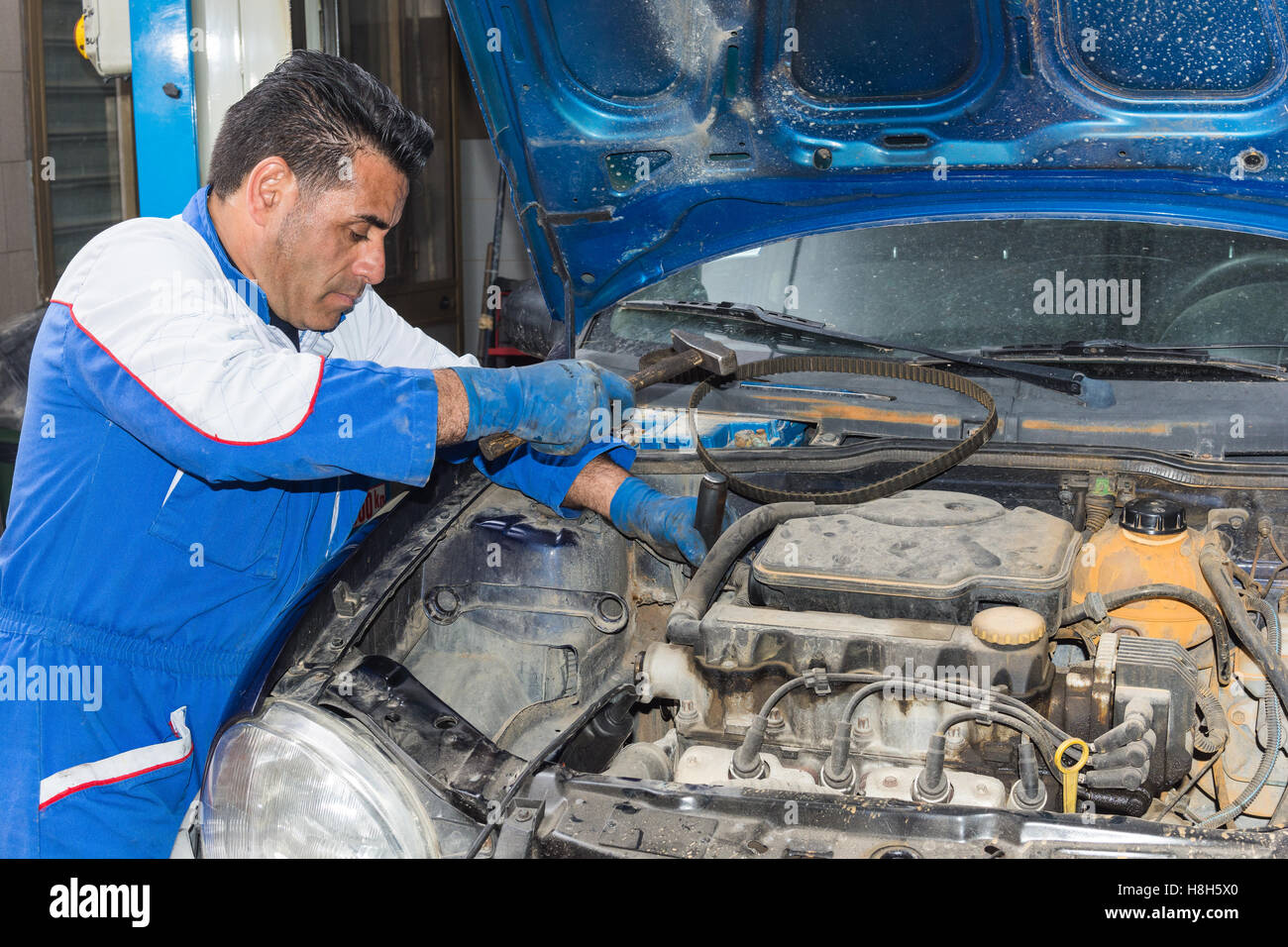 Car mechanic fixing an engine in his garage. copy space Stock Photo - Alamy