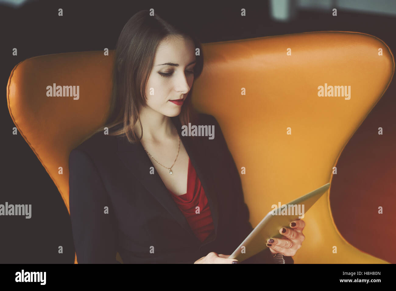 Portrait of young successful woman entrepreneur in a red dress and ...