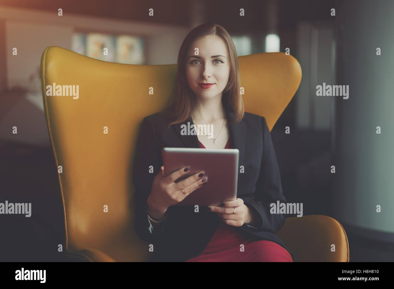 Portrait of young successful woman entrepreneur in a red dress and ...