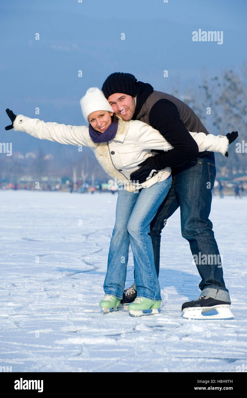 Young couple ice skating on a lake Stock Photo - Alamy