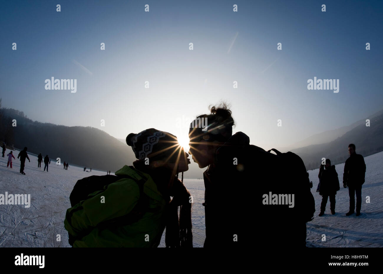 Couple kissing at the ice rink in backlighting Stock Photo - Alamy