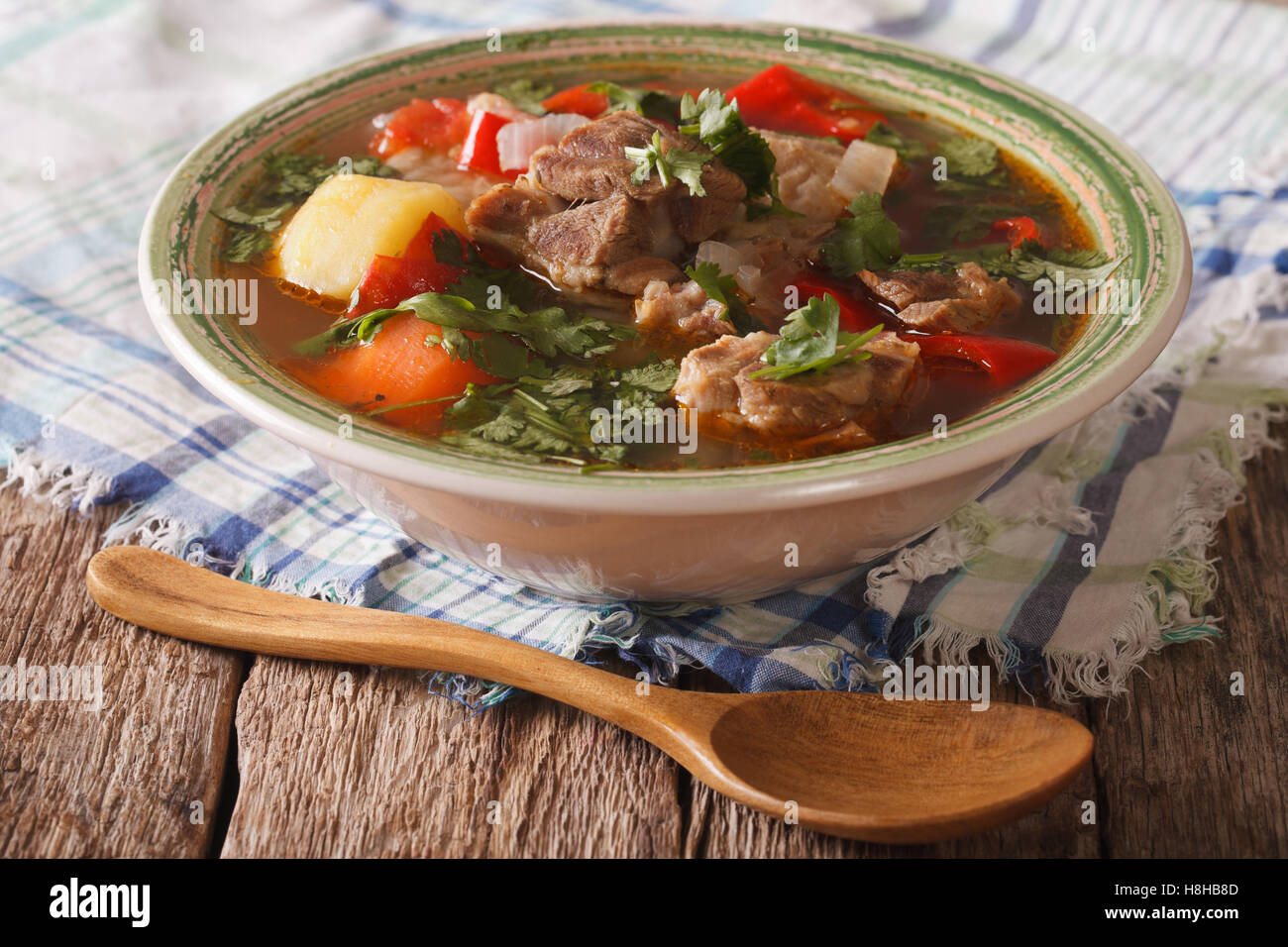 Shurpa lamb soup with vegetables closeup at the plate on the table ...