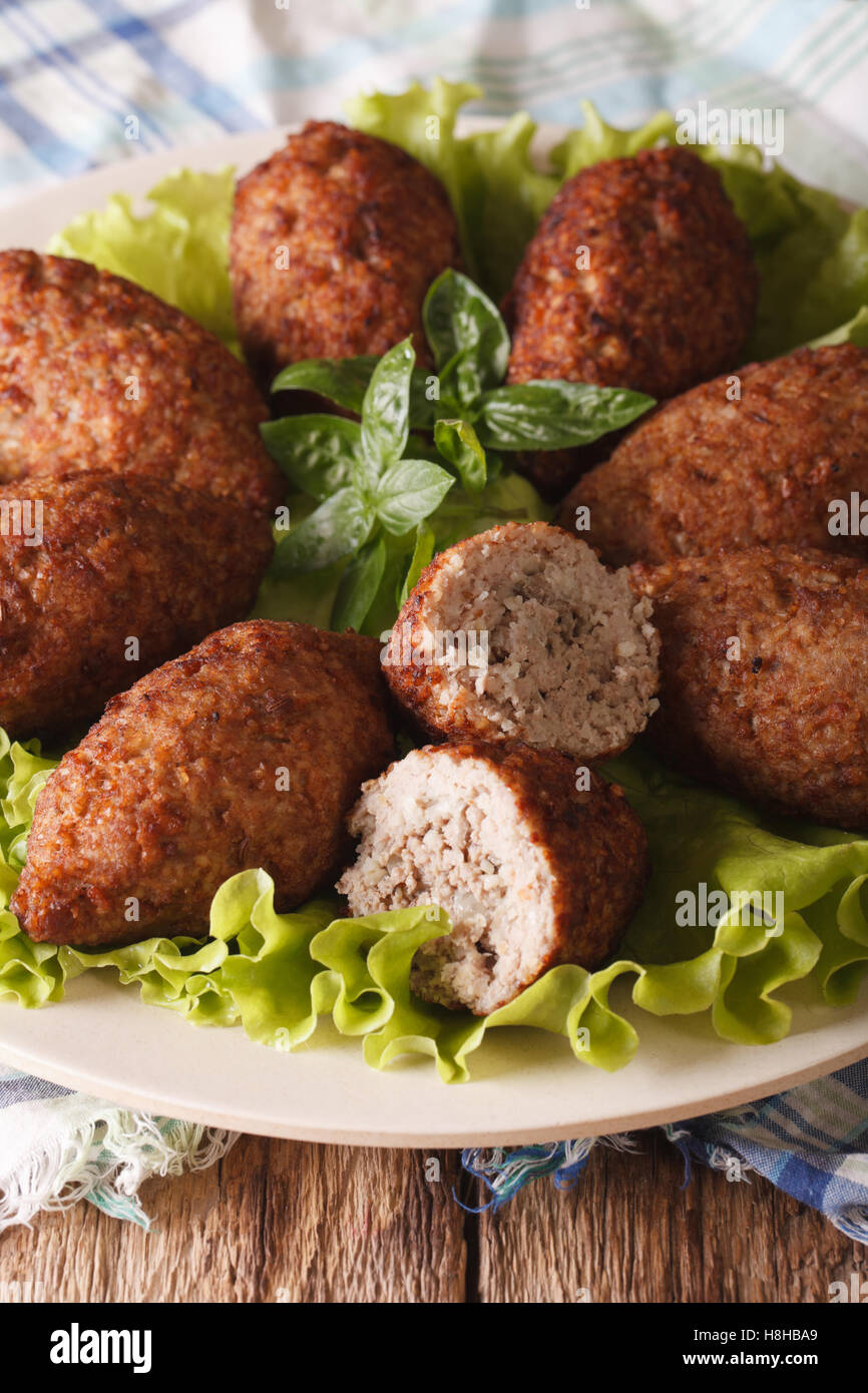 Arabic food kibbeh with bulgur and pine nuts on a plate macro. vertical ...