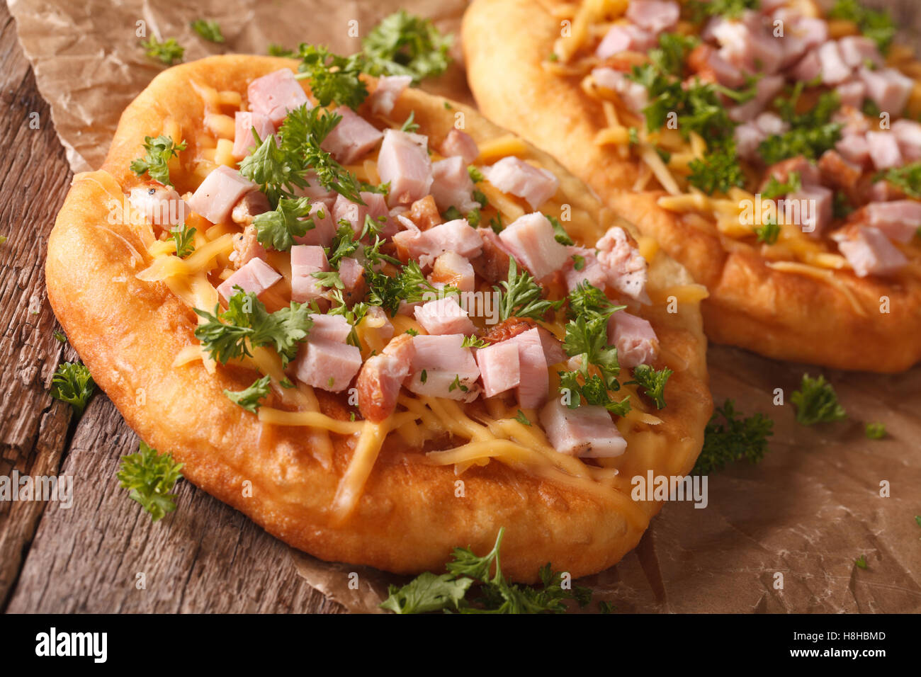 Hungarian Food: langos with ham and cheese close-up on the table ...